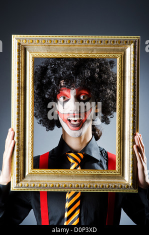 Clown with picture frames in studio Stock Photo - Alamy
