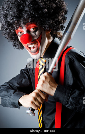 Funny clown with bat in studio Stock Photo - Alamy