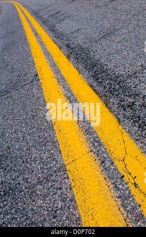 Yellow double dividing lines, highway road marking on dark asphalt ...