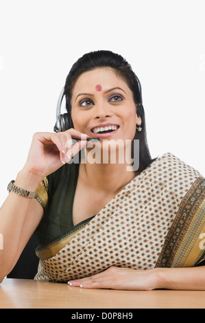 Image of pleased asian businesswoman listening to music with earphones ...