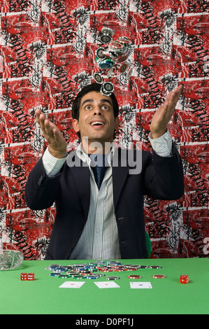 Man tossing playing cards in air with women sitting besides him Stock ...