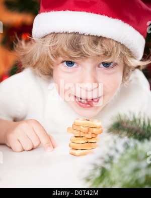 Smiling girl in Santa's hat dances with burning sparklers in the studio ...