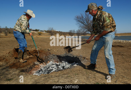 Preparing and cooking a whole wild boar (feral hog) in a pit over hot ...