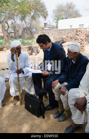 Farmers and elderly people sit on the roadside, watching a traditional ...