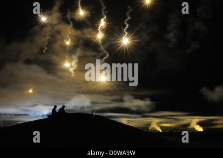US Army soldiers watch flares light up the night sky during training ...