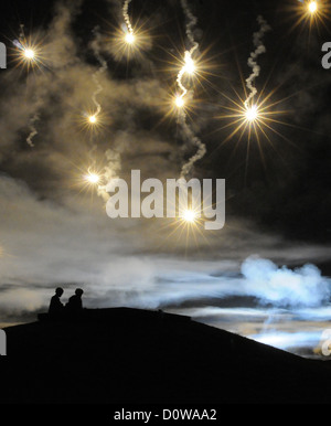 US Army soldiers watch flares light up the night sky during training ...