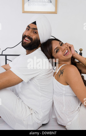 Sikh couple sitting on the bed and smiling Stock Photo - Alamy