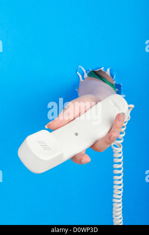 Hand with phone out of paper hole Stock Photo - Alamy