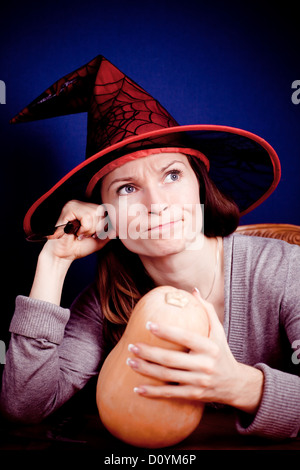 attractive woman in witch hat and wig holding magic wand in Halloween ...