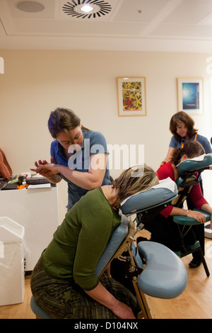 Workplace massage parlor. Workers receiving massage during their break ...