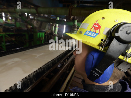 A miner observes the transportation of salt and potash on a conveyor ...