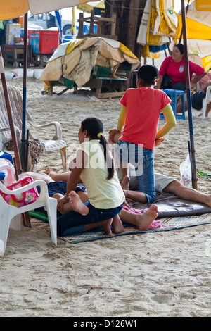Tourists enjoying a traditional Thai Massage on the Beach of Patong on Phuket Island, Thailand ...