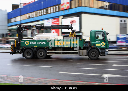 A Travis Perkins grab truck traveling around a roundabout in Coulsdon ...