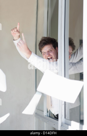 Businessman throwing papers out window Stock Photo - Alamy