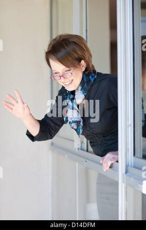 Positive delighted female person waving her hand Stock Photo - Alamy
