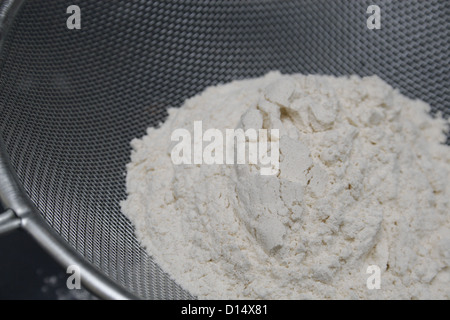 Plain flour being sieved into a mixing bowl Stock Photo - Alamy