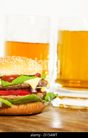 A vertical shot of a delicious big beef burger with french fries on a ...