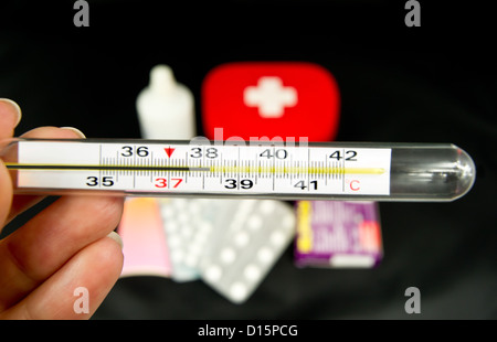 Hand holding thermometer and pills for fever and illness Stock Photo ...