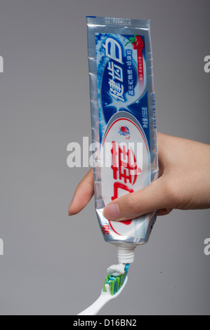 Woman's hand squeezing toothpaste onto a toothbrush Stock Photo - Alamy