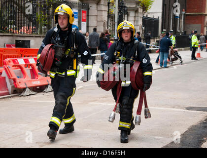 Firefighter carrying hoses during a fire at a hotel in East London ...