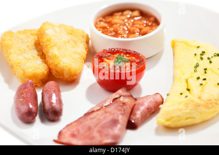 A traditional breakfast consists of bacon, sausage, tomato, hash browns, egg & baked beans, with ...
