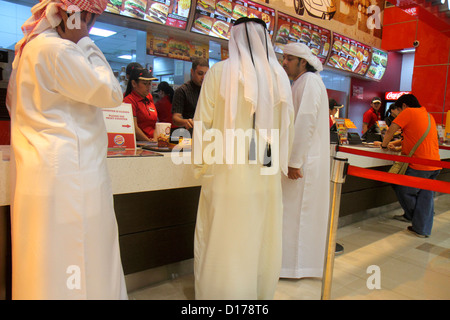 Arabic man at restaurant eating burger Stock Photo - Alamy