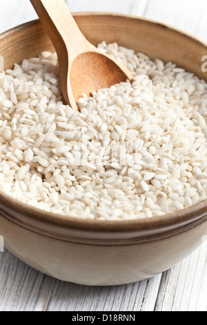 Raw rice in bowl, spoon and burlap fabric on wooden table, flat lay ...