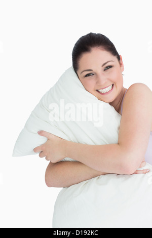 Young woman hugging a white pillow on blue background Stock Photo - Alamy