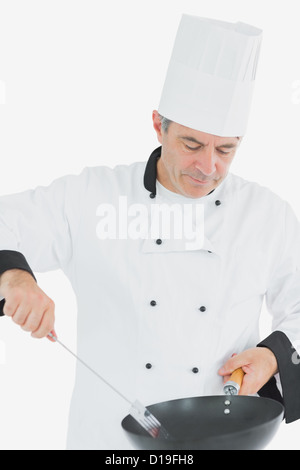 Male chef using spatula and frying pan over white background Stock ...