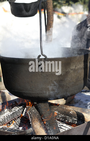 Big kettles over an open wood fire, boiling maple sap outdoors to ...