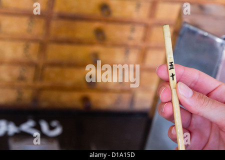 TOKYO, JAPAN A tourist chooses a fortune-telling stick at the Asakusa ...