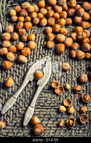 Closeup hazelnuts with nutcracker in old basket Stock Photo - Alamy
