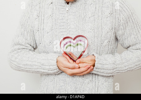 Three colored metal heart symbols held in the hands of a man Stock ...