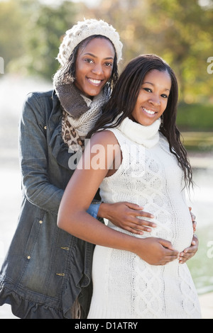 Portrait of happy woman embracing friend while standing at beach Stock ...