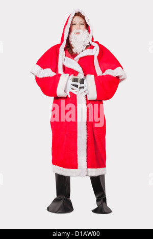 Young woman in Santa costume with candy canes sitting near white door ...