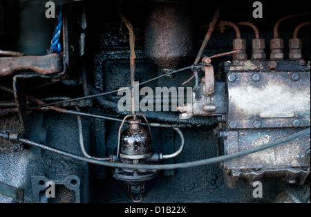 Detail of the engine of an old tractor showing greasy engine parts ...