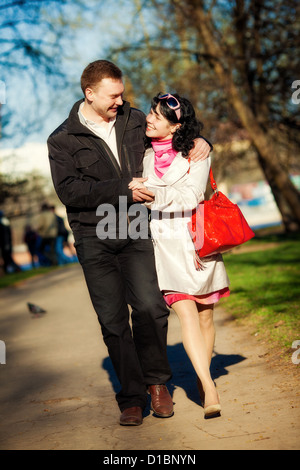 Loving couple is outdoors in the park, they are happy together and ...