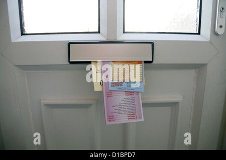 Leaflets through letterbox Stock Photo - Alamy