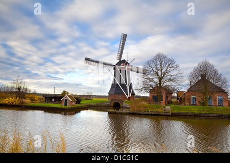Dutch windmill and farmhouse by canal Stock Photo - Alamy