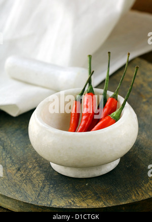 Red hot chili peppers and marble mortar with spices on dark wooden ...