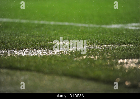 Heavy rain falling on waterlogged turf football pitch with standing ...