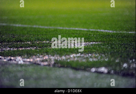 Heavy rain falling on waterlogged turf football pitch with standing ...
