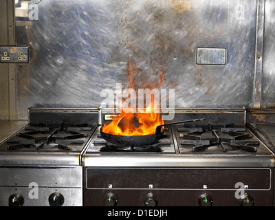 A flaming pan cooking on a hob Stock Photo: 27746341 - Alamy