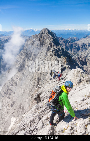 Mountaineer climbing on the Watzmann ridge, in the back the middle peak ...