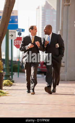 Two businessmen walking on sidewalk Stock Photo - Alamy