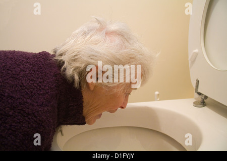 Close up elderly woman suffering from Norovirus winter vomiting bug ...