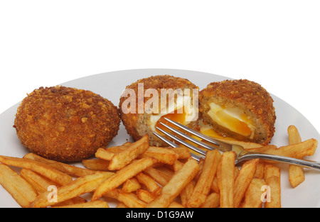 Runny Scotch egg and potato chips with a fork on a plate Stock Photo ...