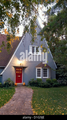 Exterior gray cottage style house with pointed roof and red door Stock ...