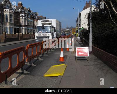 Road sign approaching urban roadworks site on busy road traffic ...