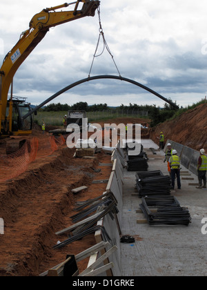 tracked excavator craning in lengths of steel reinforcing bar bars ...